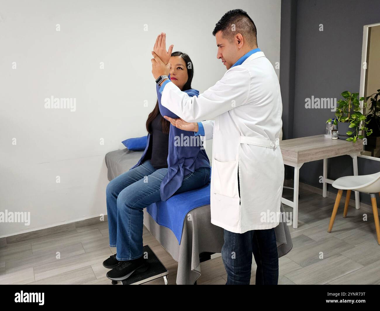 Dark-skinned man doctor medical specialist checks Latin woman patient ...
