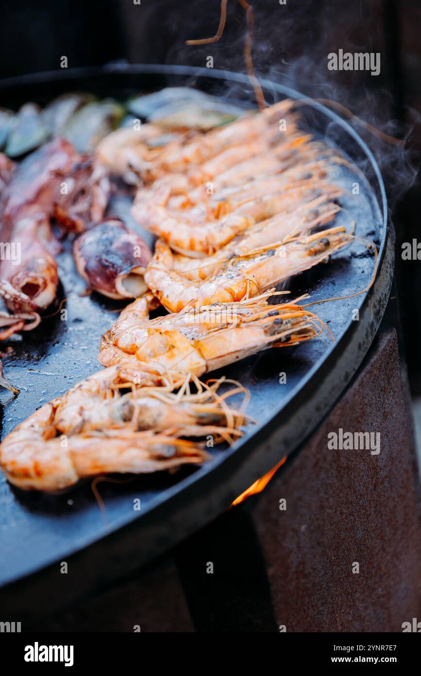 Grilled shrimp sizzling on a hot plate, releasing steam and flavors for ...