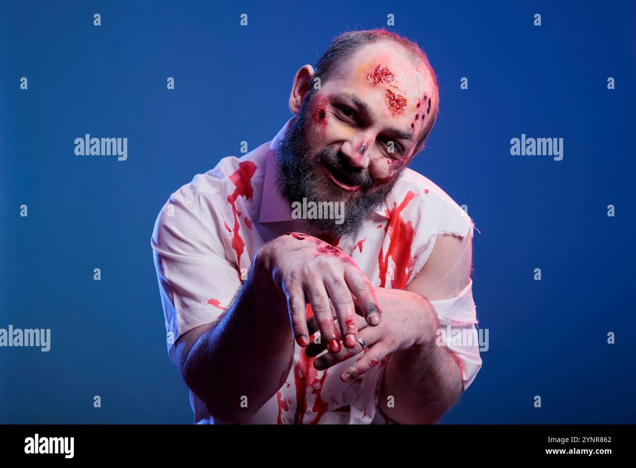 Portrait of devilish possessed zombie with blood on face and clothes ...