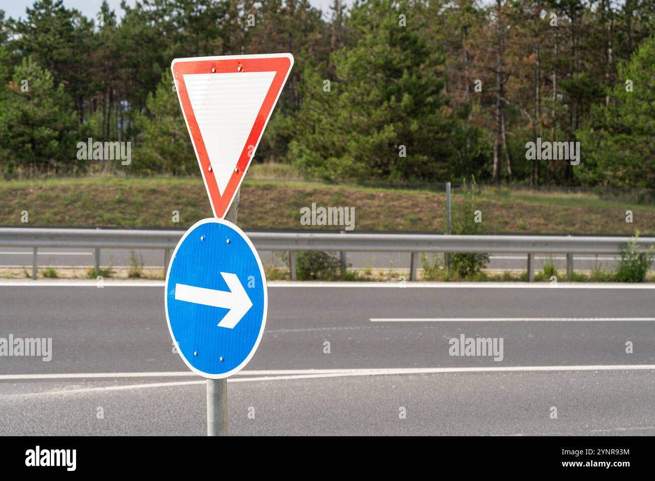 Traffic signs indicating priority and direction on an empty European ...