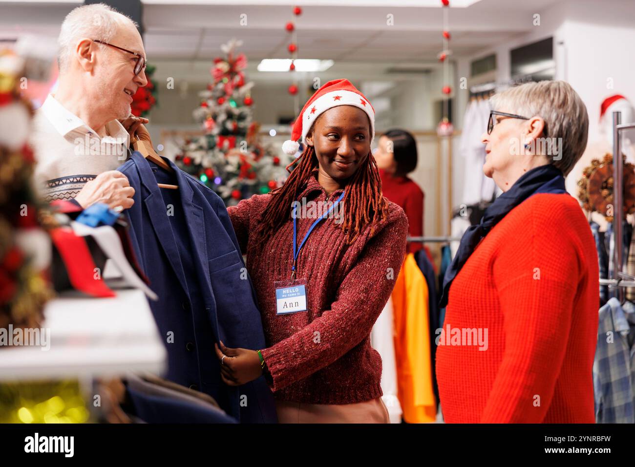 Retail worker showing blazer to old clients, recommending perfect items ...