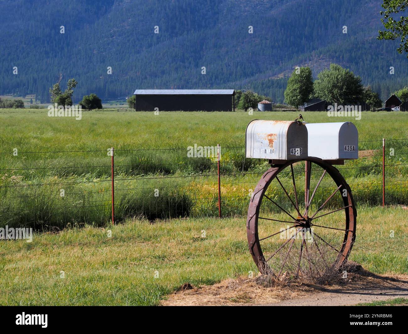 Two mail boxes are affixed to an iron wagon wheel in a remote rural ...