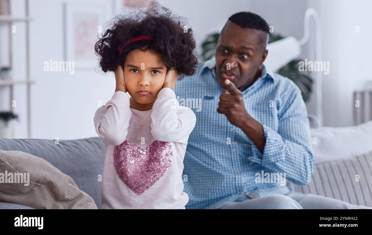 Angry African American grandfather shouting at his granddaughter at ...