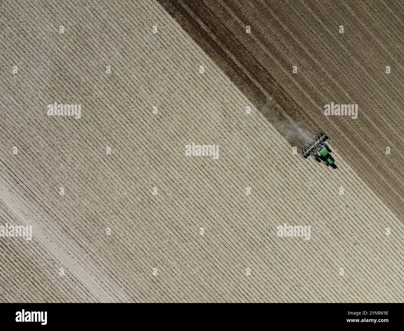 Overhead view of a farmer plowing a field and preparing for crops Stock ...