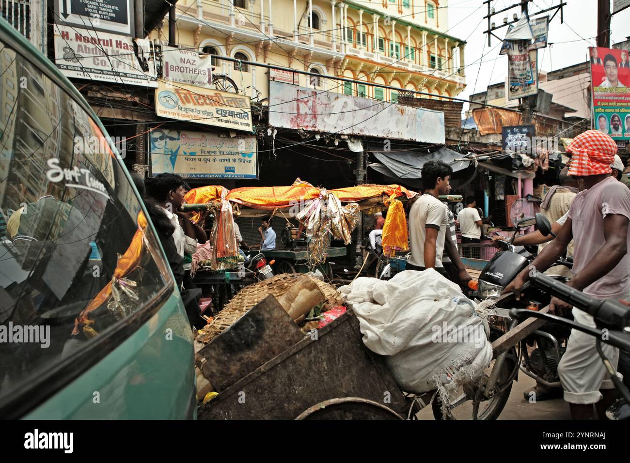 Men carrying a body as they are walking on a busy road, heading to one ...