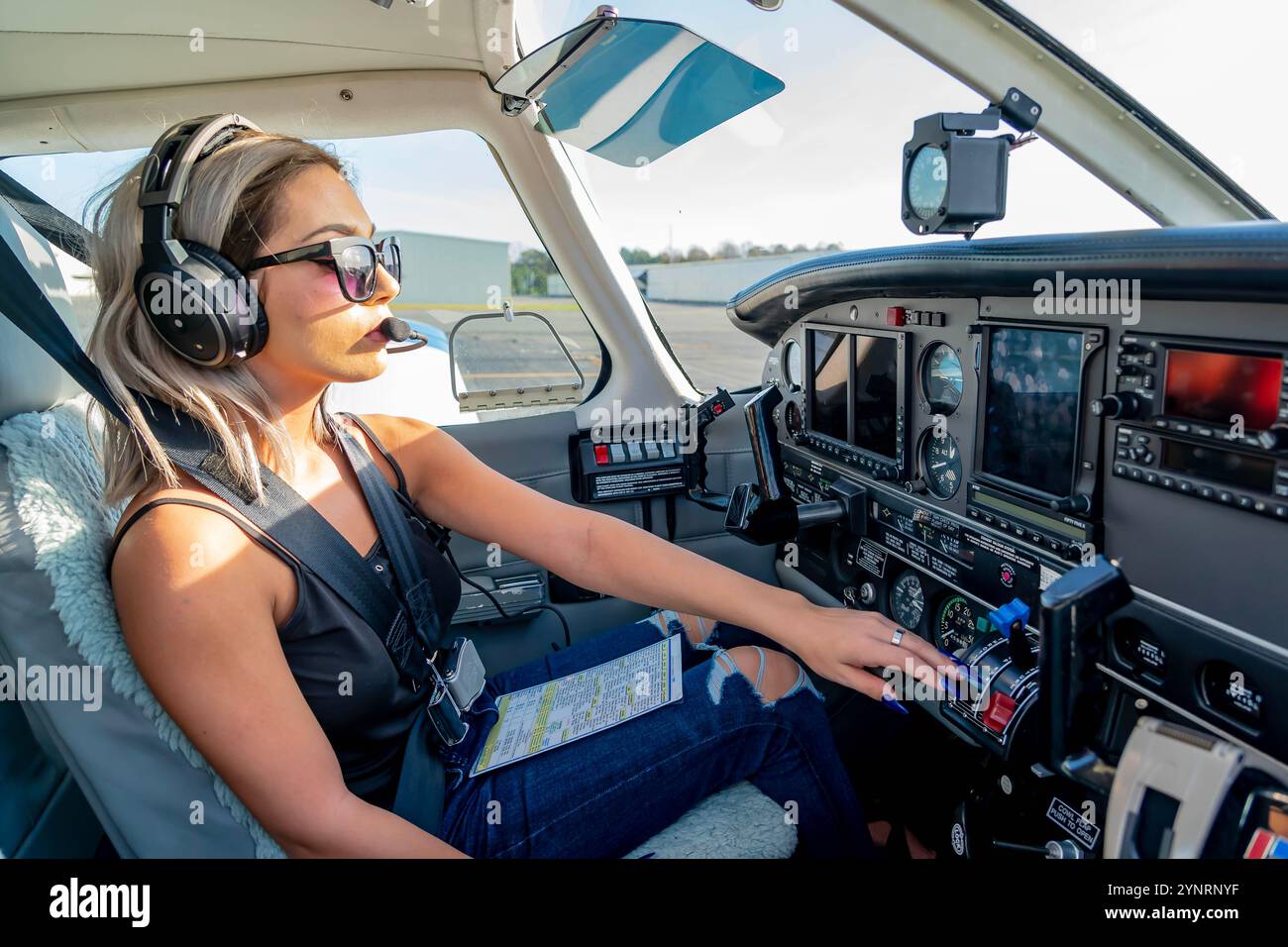 A young woman pilot diligently performs pre-flight checks beside her ...