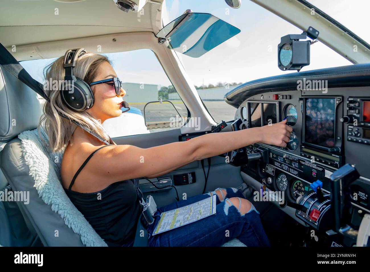 A young woman pilot diligently performs pre-flight checks beside her ...