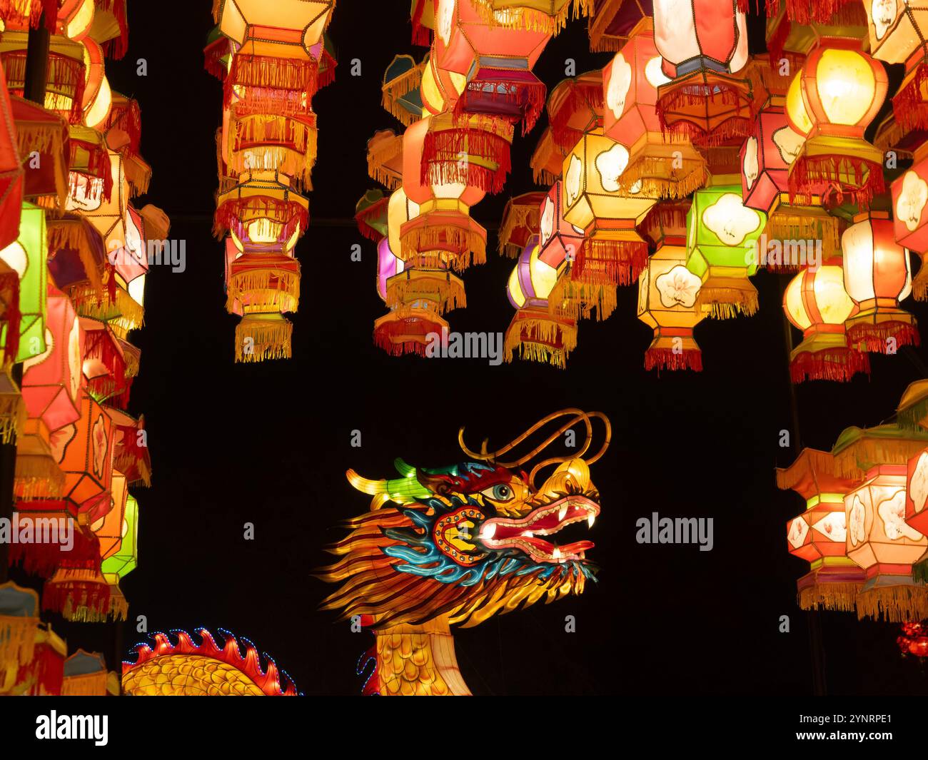 Rows of illuminated orange and red fabric Chinese lanterns in a tunnel ...