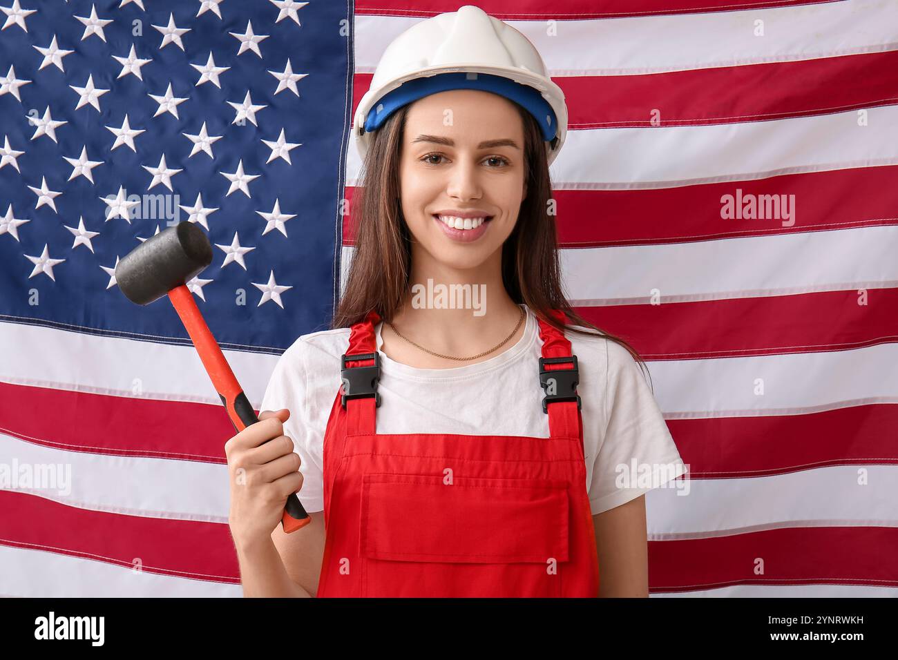 Female construction worker with rubber mallet against USA flag ...