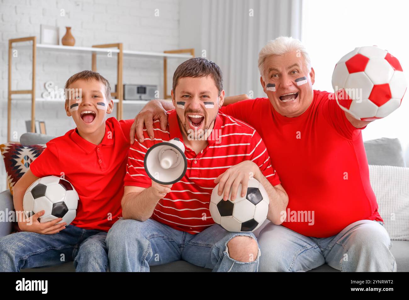 Man with his father and son cheering for football team with megaphone ...