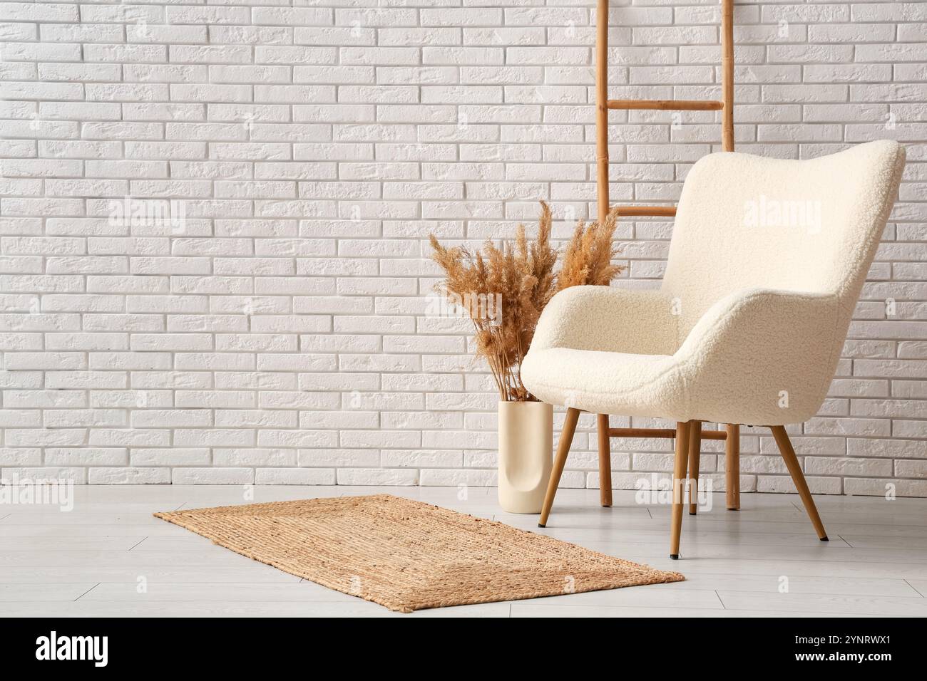 White armchair, ladder and pampas grass in living room Stock Photo - Alamy