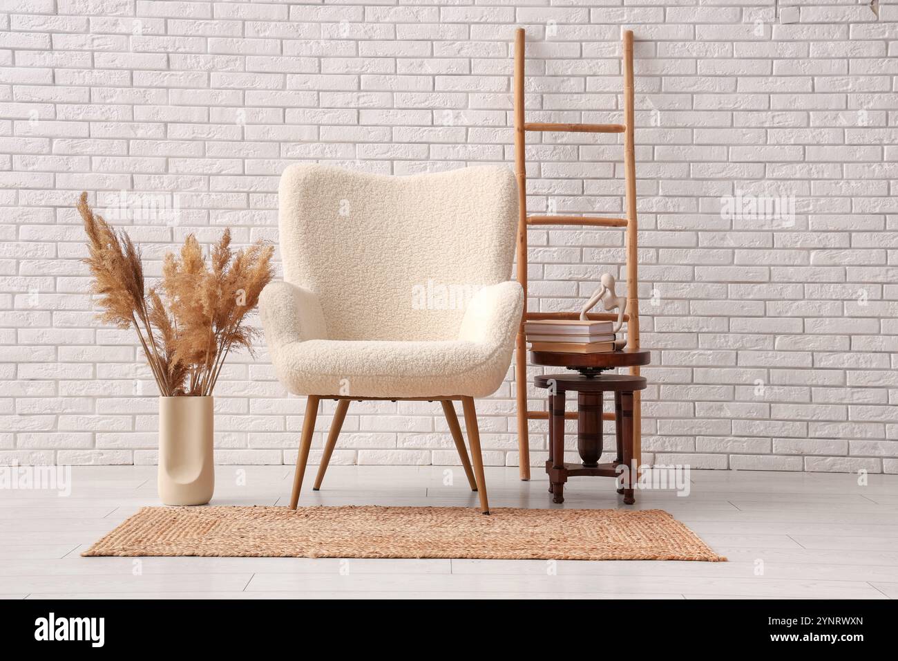 White armchair coffee table with books, ladder and pampas grass in ...