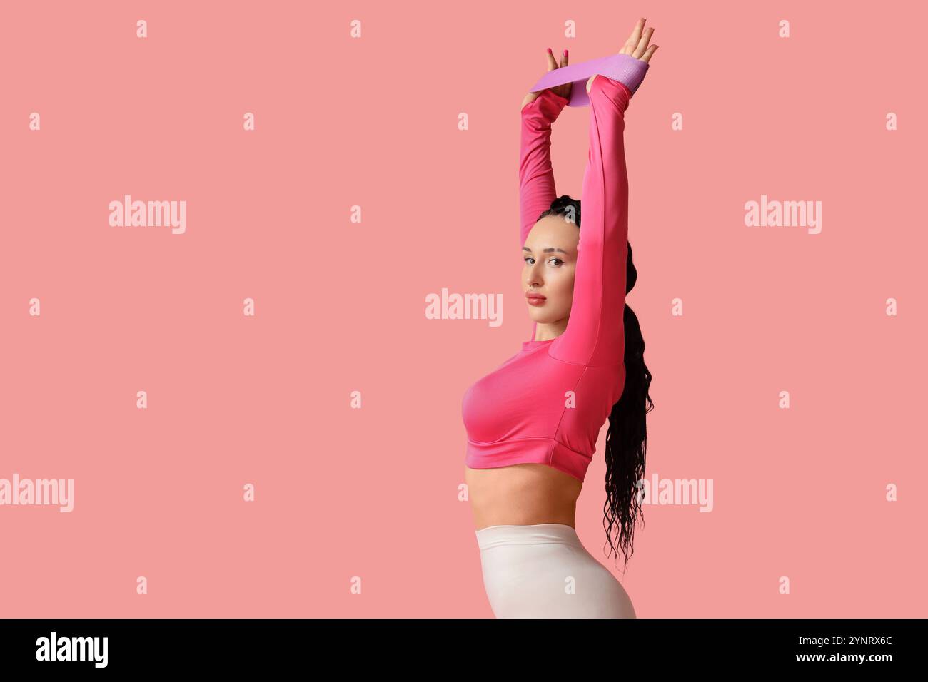 Female bodybuilder with stretching band on pink background Stock Photo ...