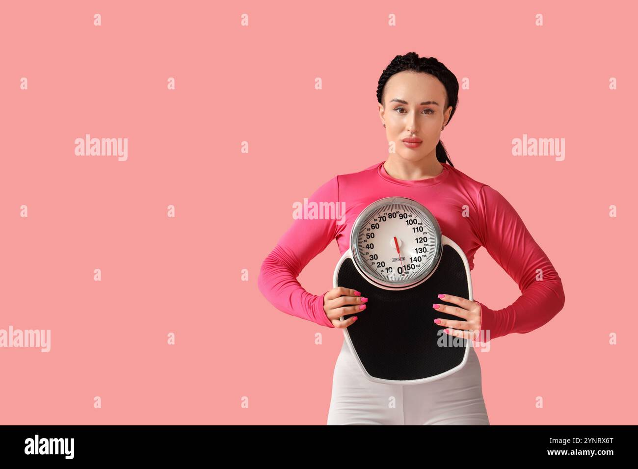 Female bodybuilder with weight scales on pink background Stock Photo ...