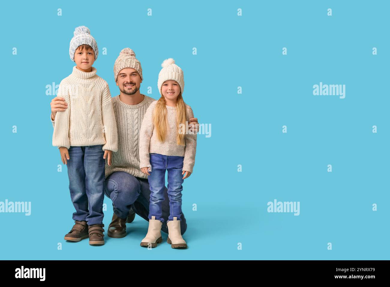 Happy father with children in winter clothes on blue background Stock ...