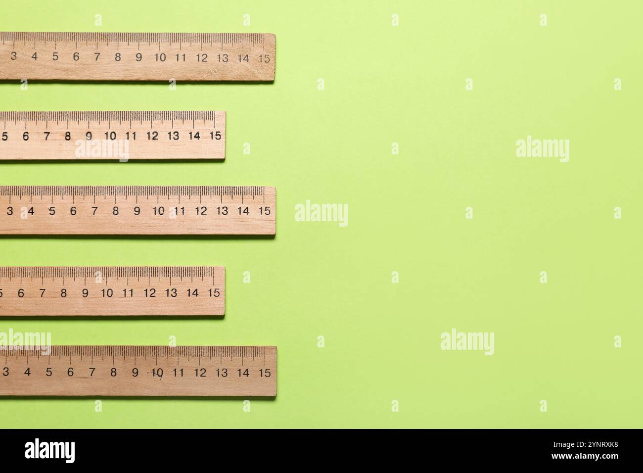 Set of wooden rulers on green background Stock Photo - Alamy