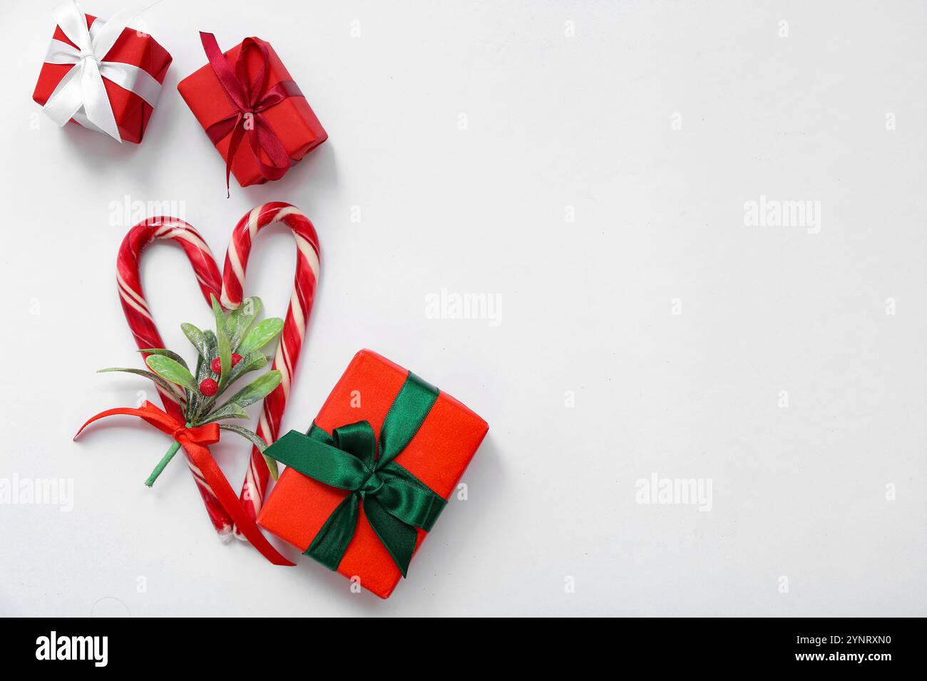 Christmas gift boxes with mistletoe and candy cane toys on white ...