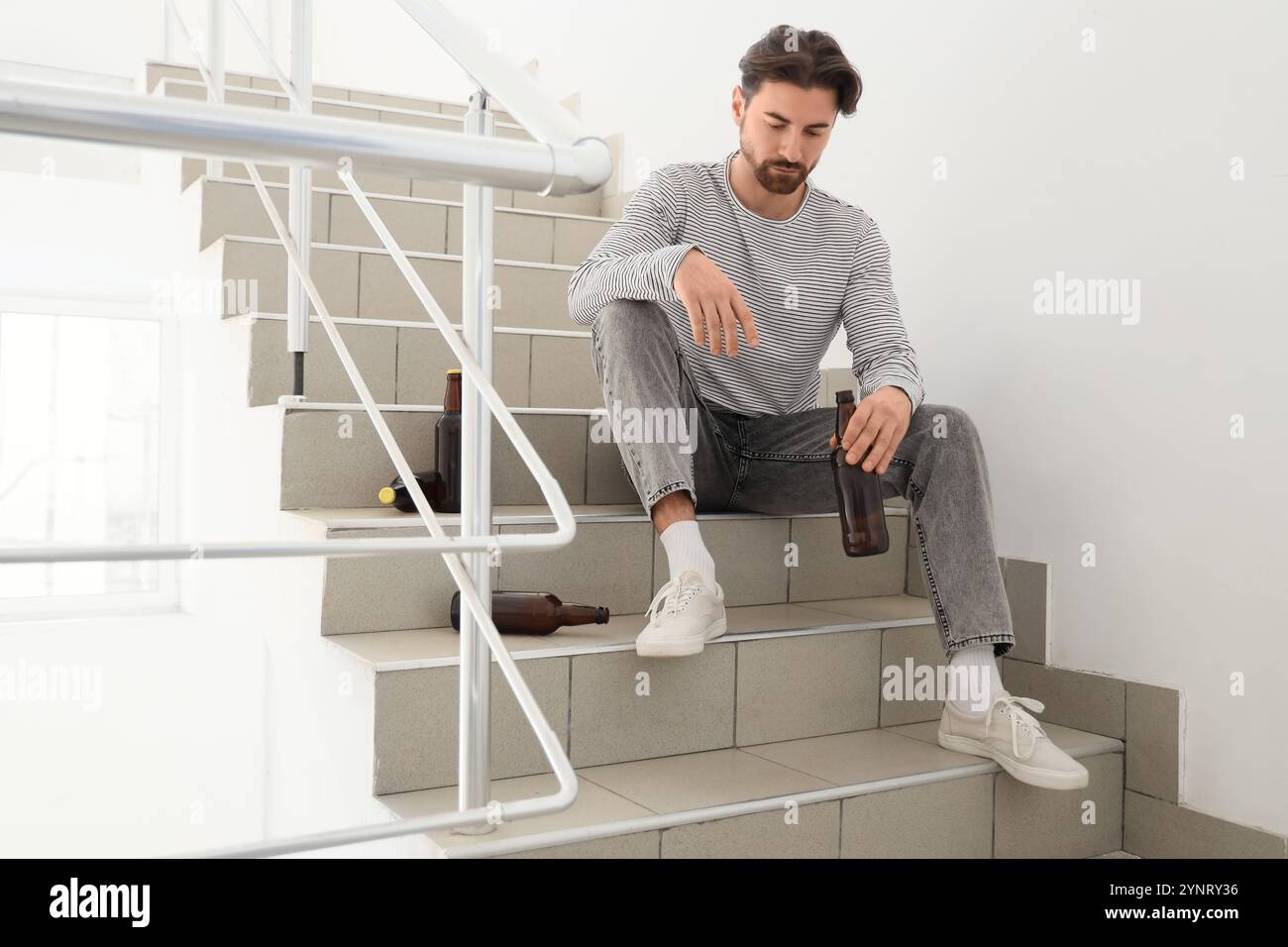 Drunk man sitting on stairs. Alcoholism concept Stock Photo - Alamy