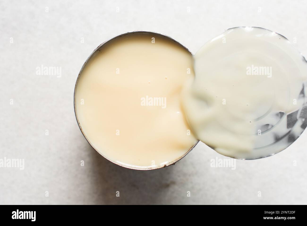 Overhead view of an opened tin of condensed milk with the lid, top view ...