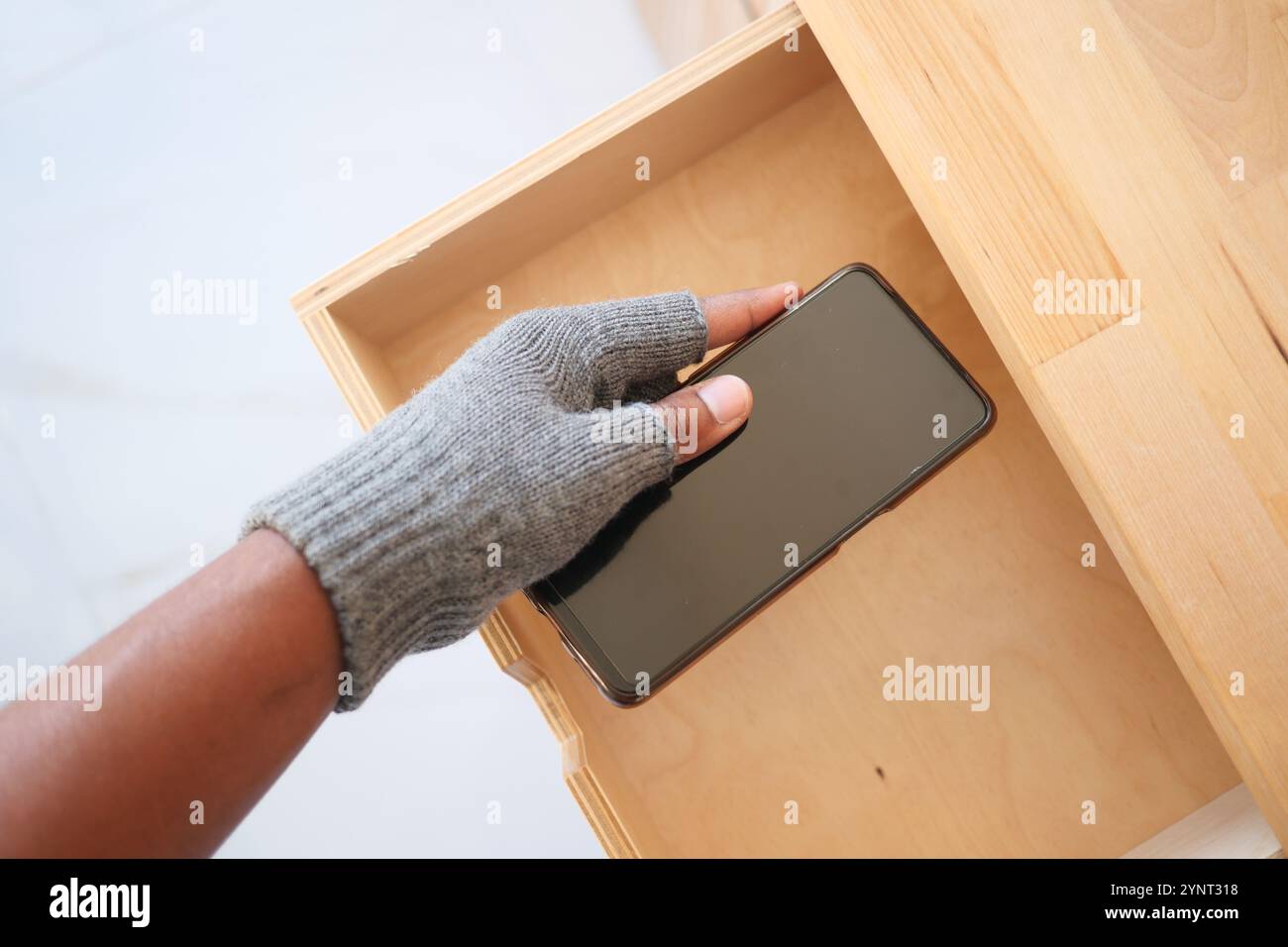 Person Stealing Smartphone from an Open Wooden Drawer Stock Photo - Alamy