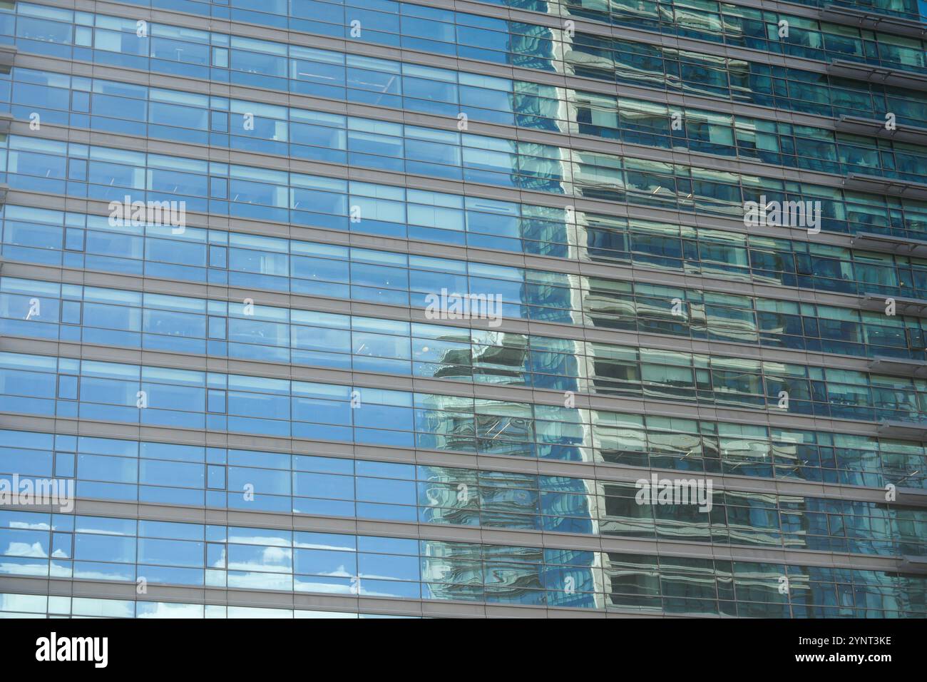 A modern office building facade with large glass windows that reflect ...