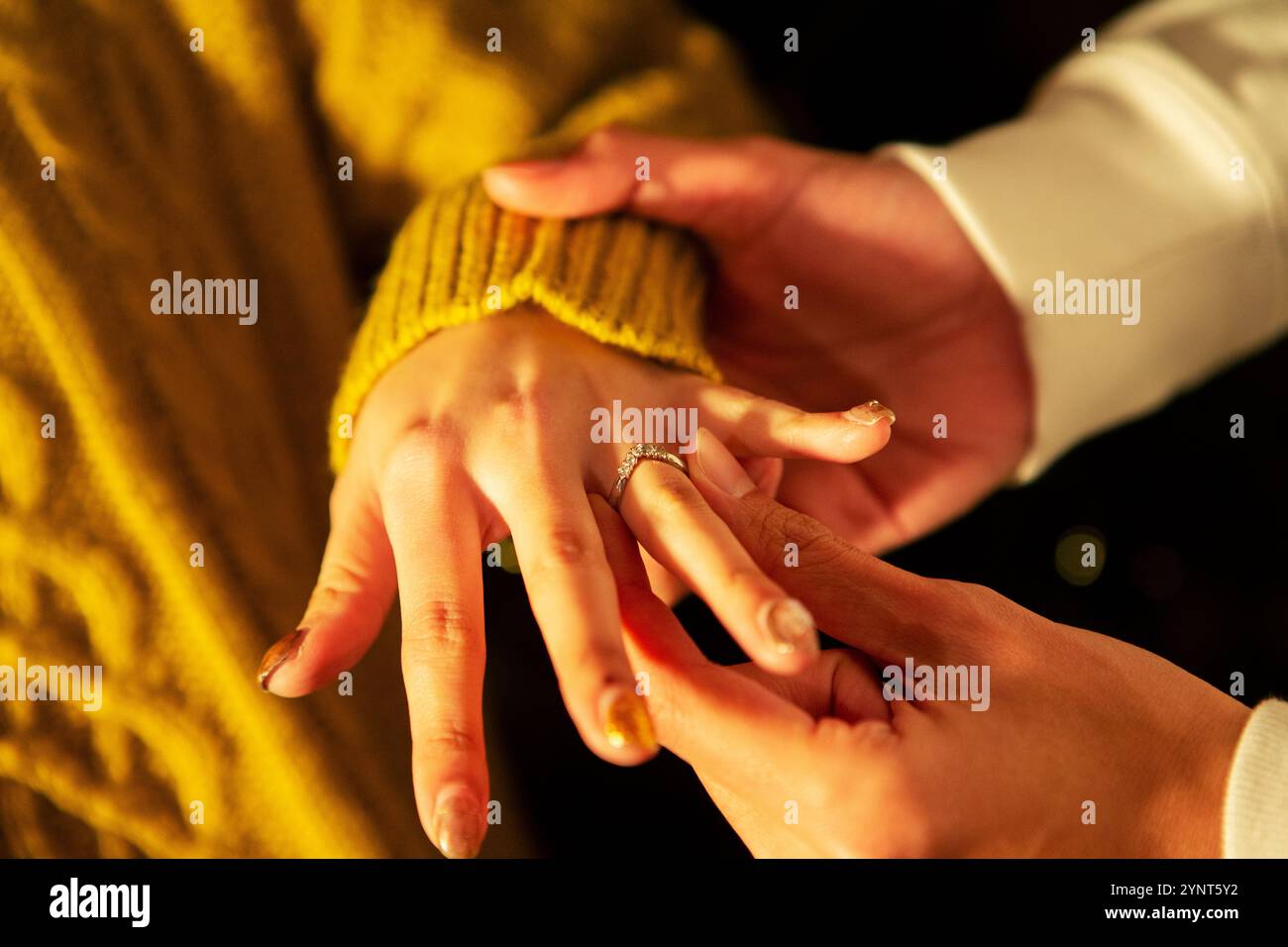 Man's hand placing ring on woman's ring finger Stock Photo - Alamy