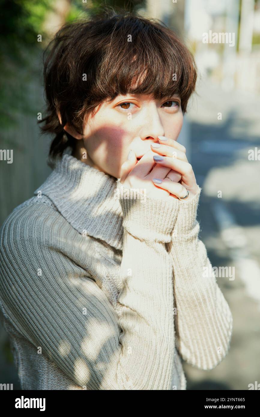 Woman in her 20s warming her biting hands Stock Photo - Alamy