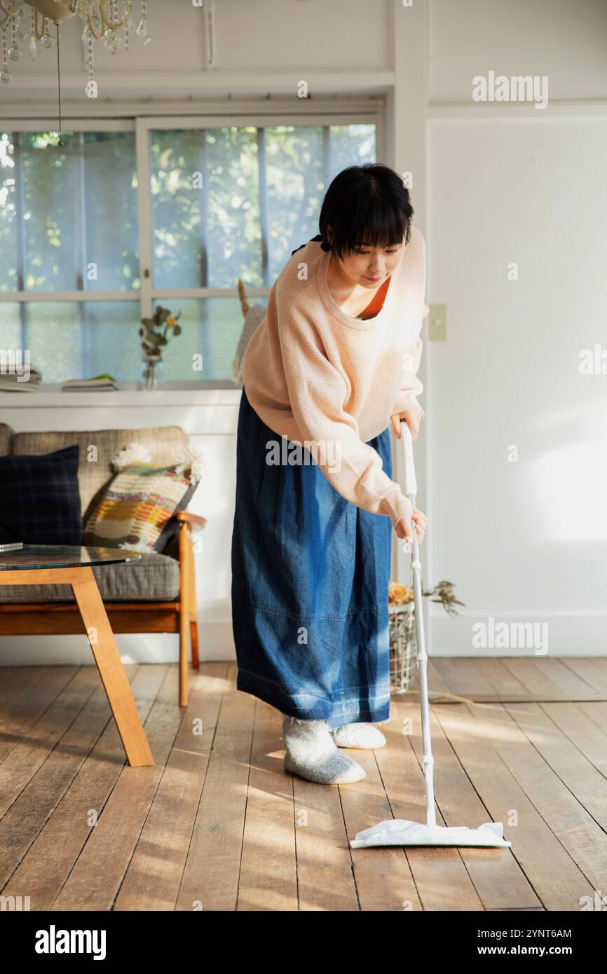 Woman in her 20s cleaning the room Stock Photo - Alamy