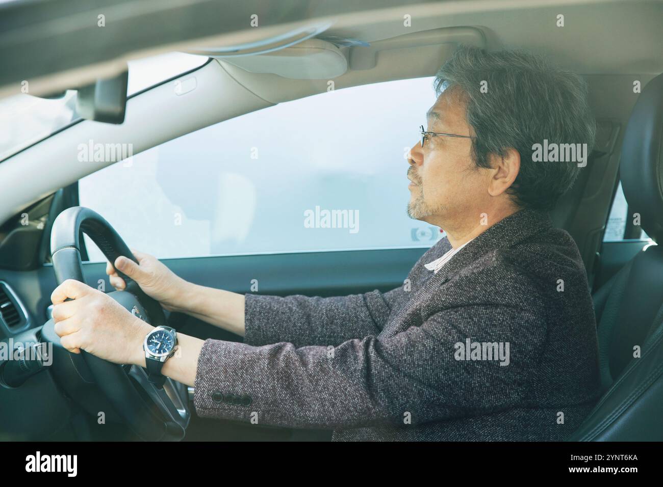 Man in his 60s holding a steering wheel Stock Photo - Alamy