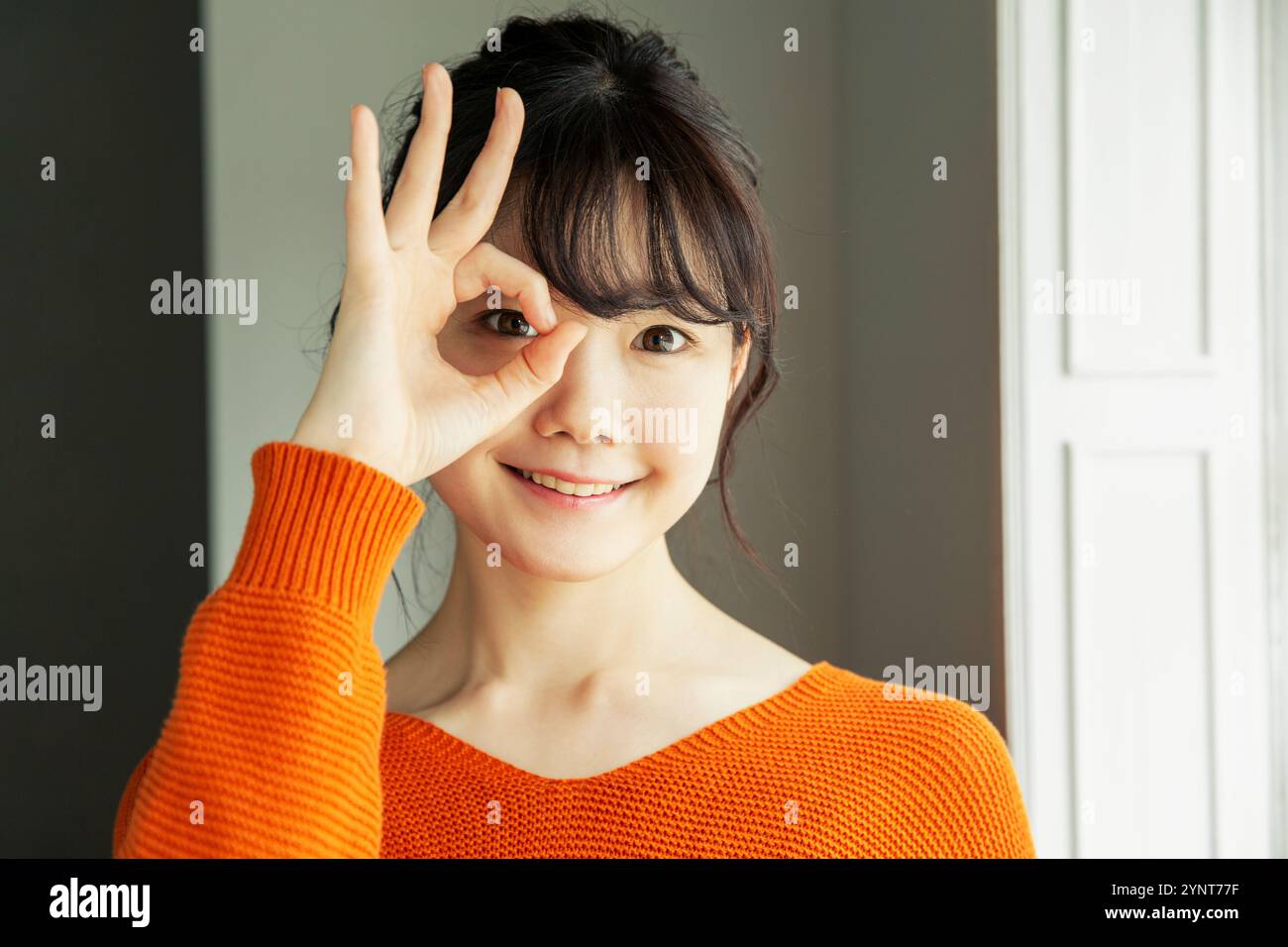 Smiling 20s woman giving the ‘okaye’ sign Stock Photo - Alamy