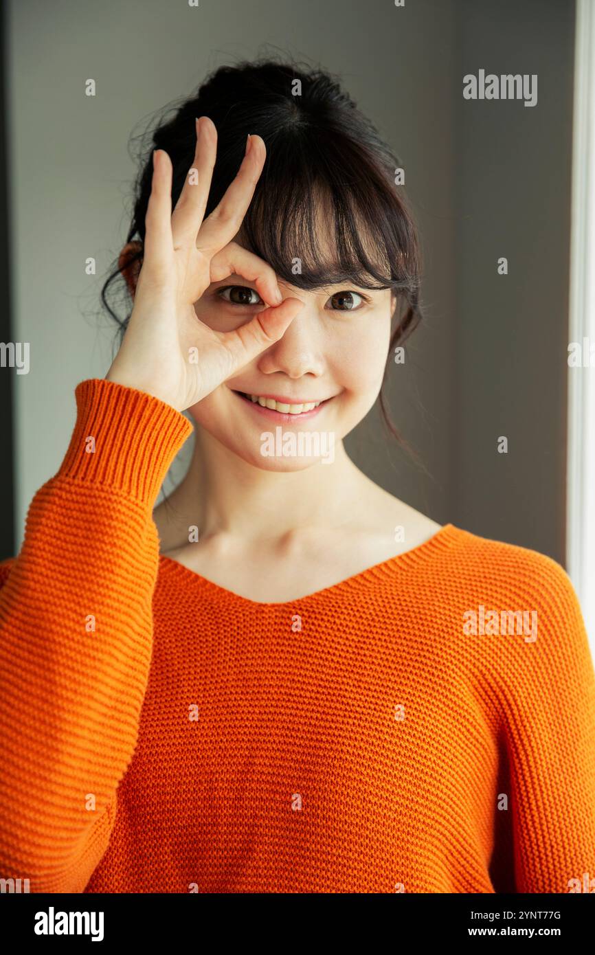 Smiling 20s woman giving the ‘okaye’ sign Stock Photo - Alamy