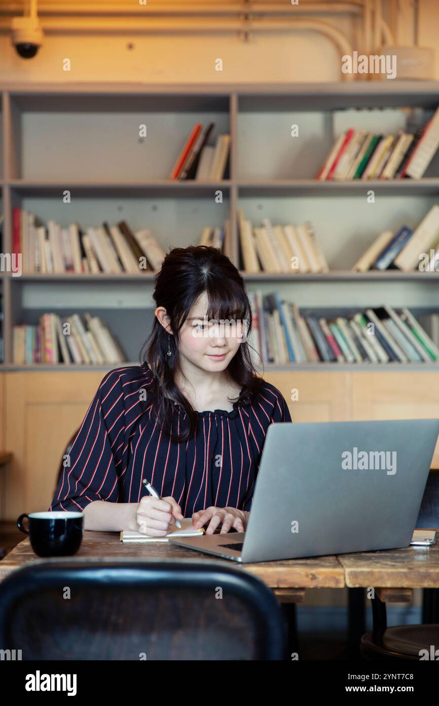 Woman in her 20s operating a computer Stock Photo - Alamy