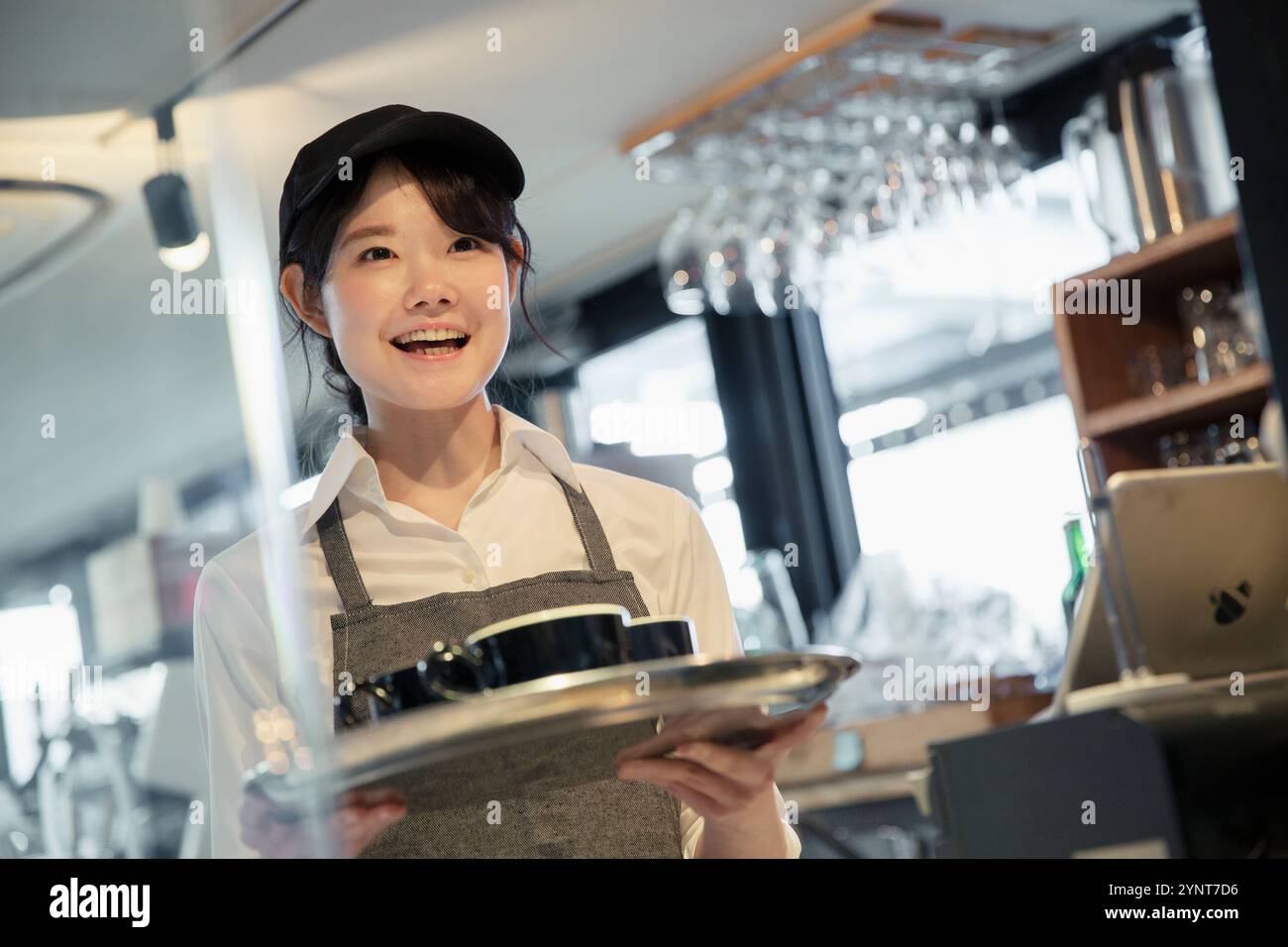 Female café worker in her 20s serving drinks Stock Photo - Alamy