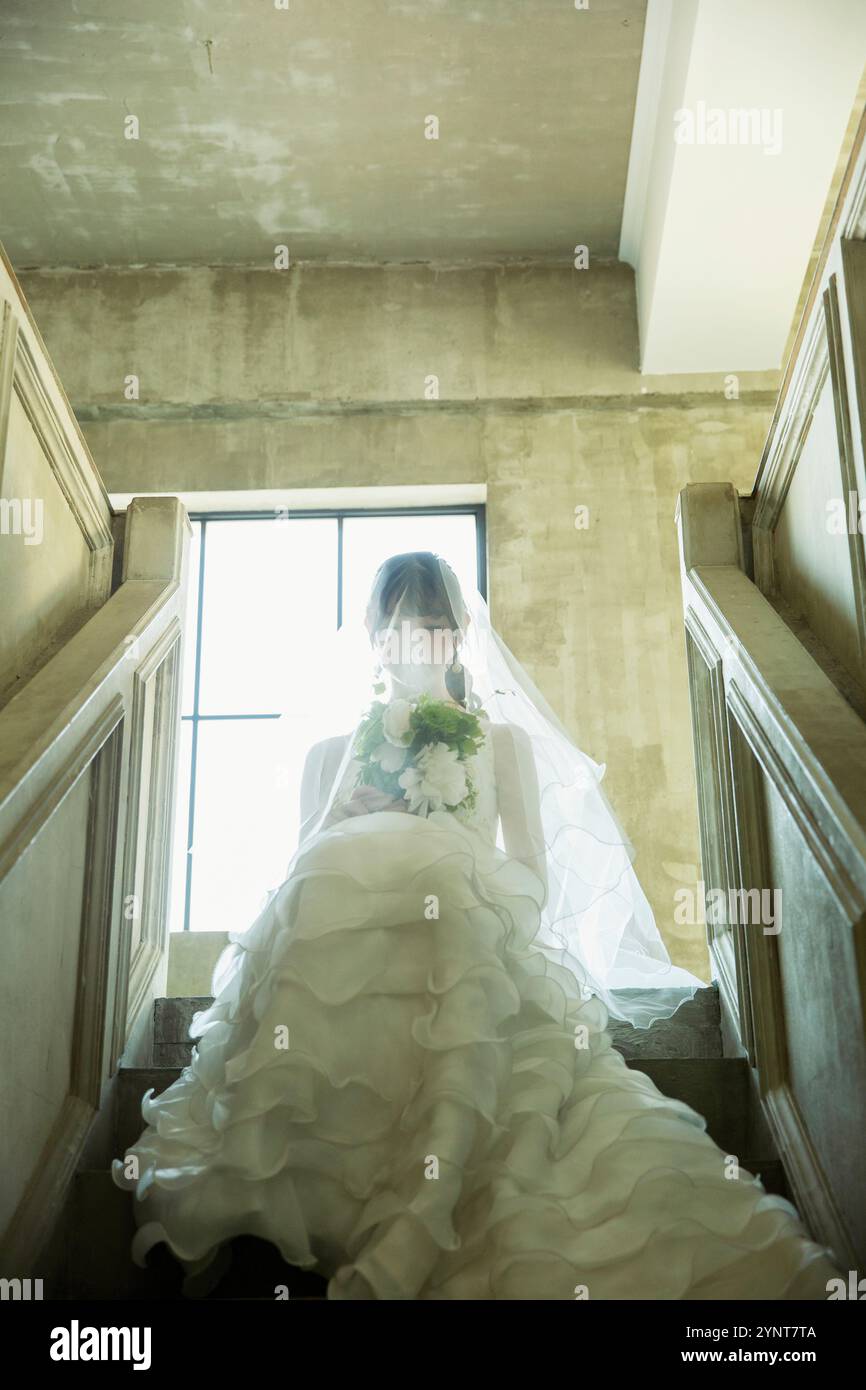 Woman in her 20s in dress sitting on stairs Stock Photo - Alamy