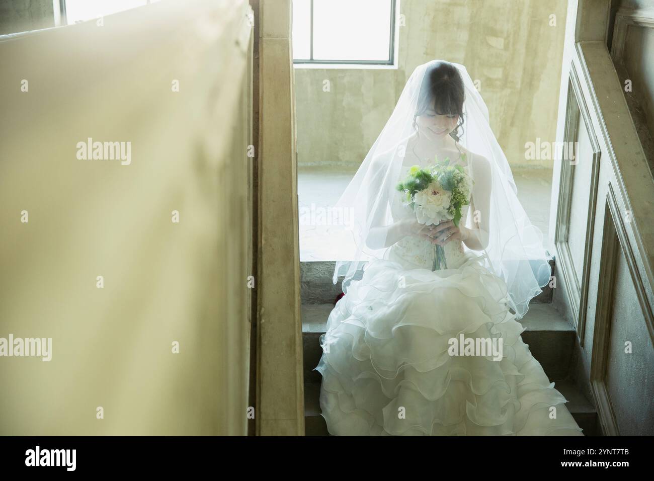 Woman in her 20s in dress sitting on stairs Stock Photo - Alamy
