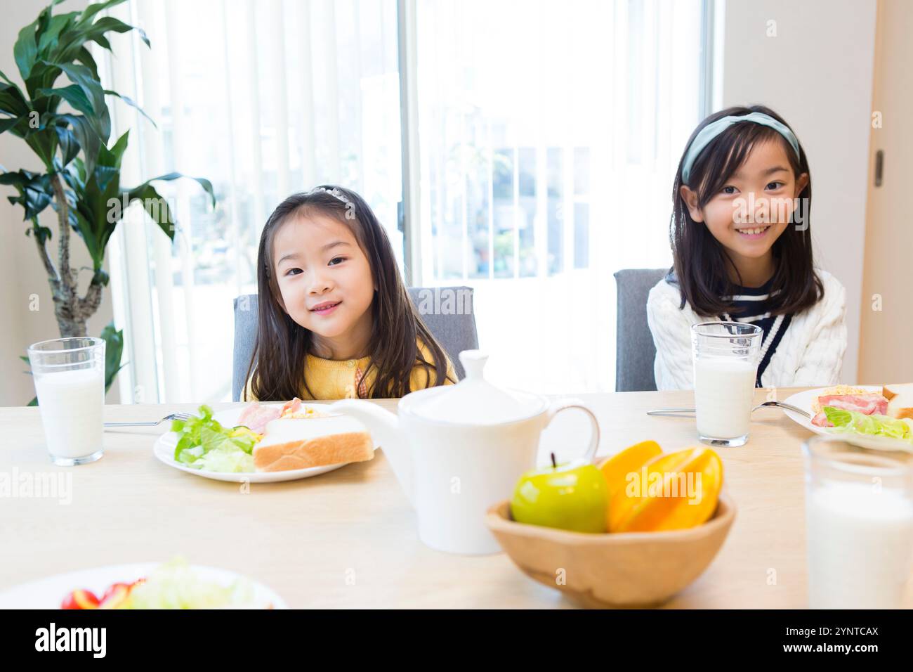 Breakfast scene with sisters Stock Photo - Alamy
