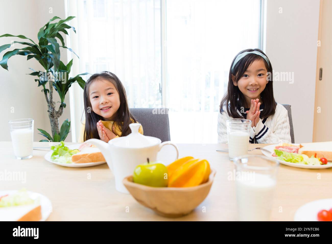 Breakfast scene with sisters Stock Photo - Alamy