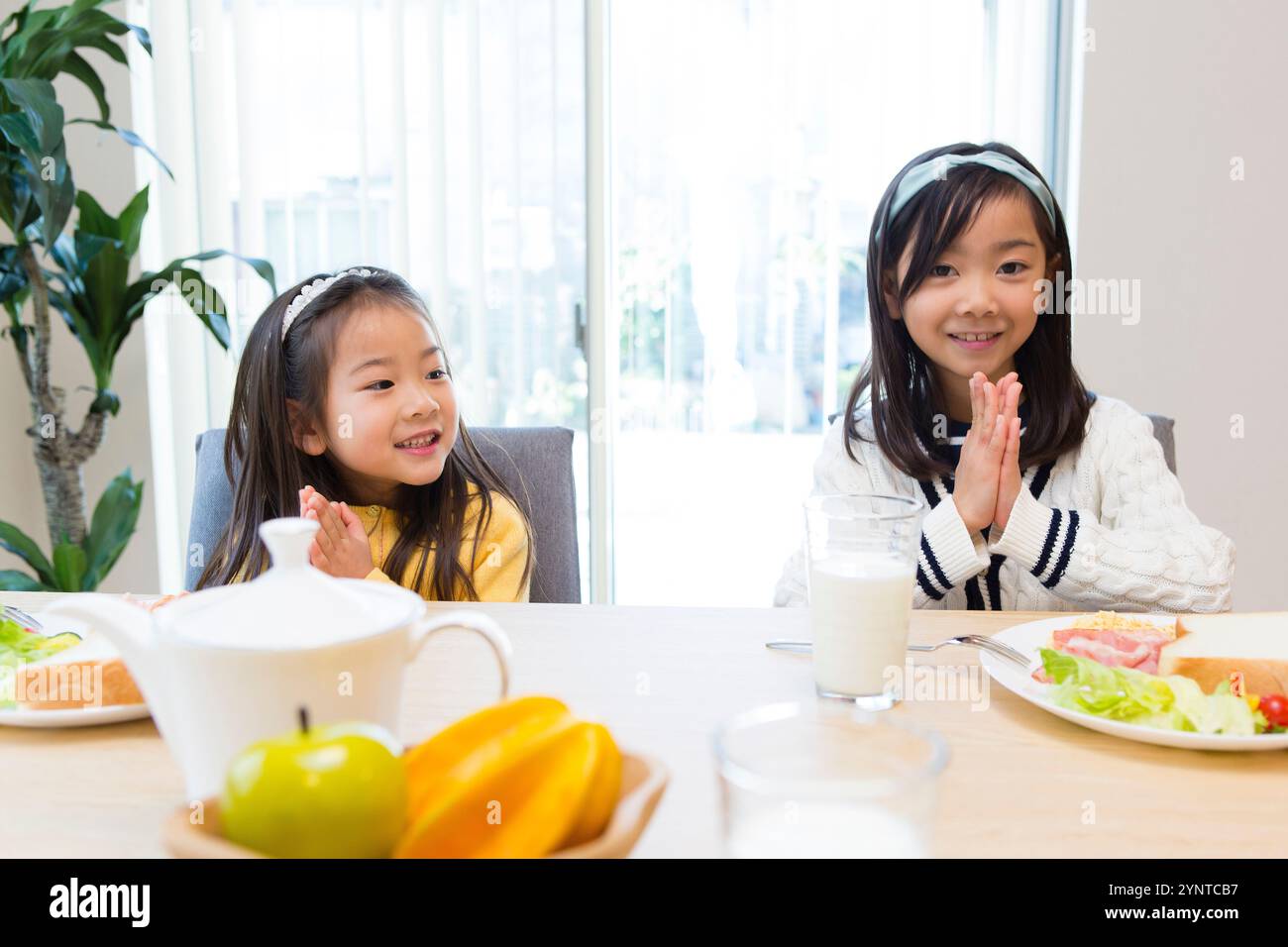 Breakfast scene with sisters Stock Photo - Alamy
