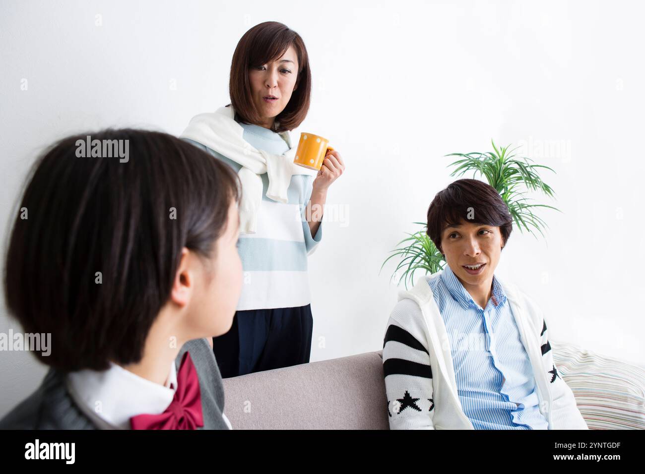 Family grouping together in a room Stock Photo - Alamy