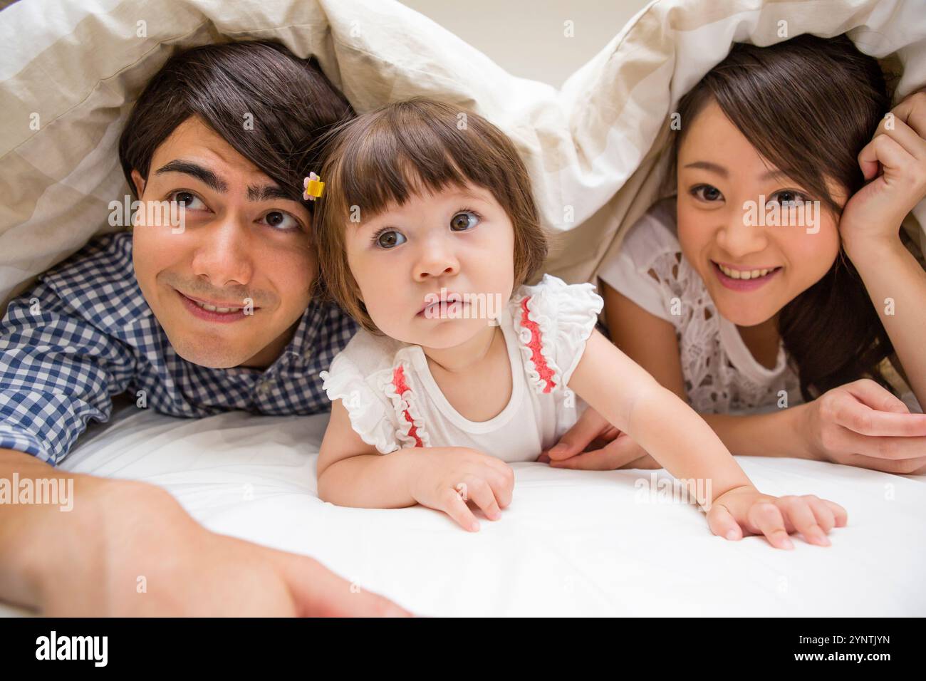 Family hiding under the duvet Stock Photo - Alamy