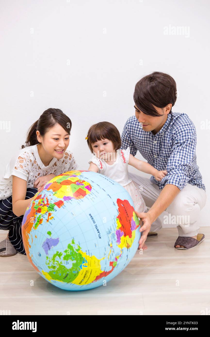 Family looking at a globe Stock Photo - Alamy