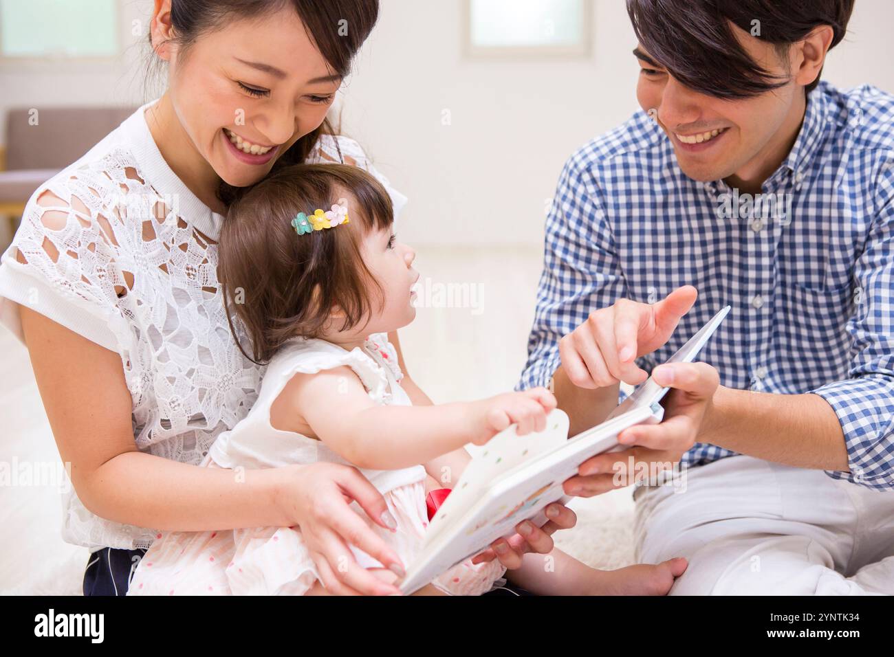Family reading a book to their child Stock Photo - Alamy