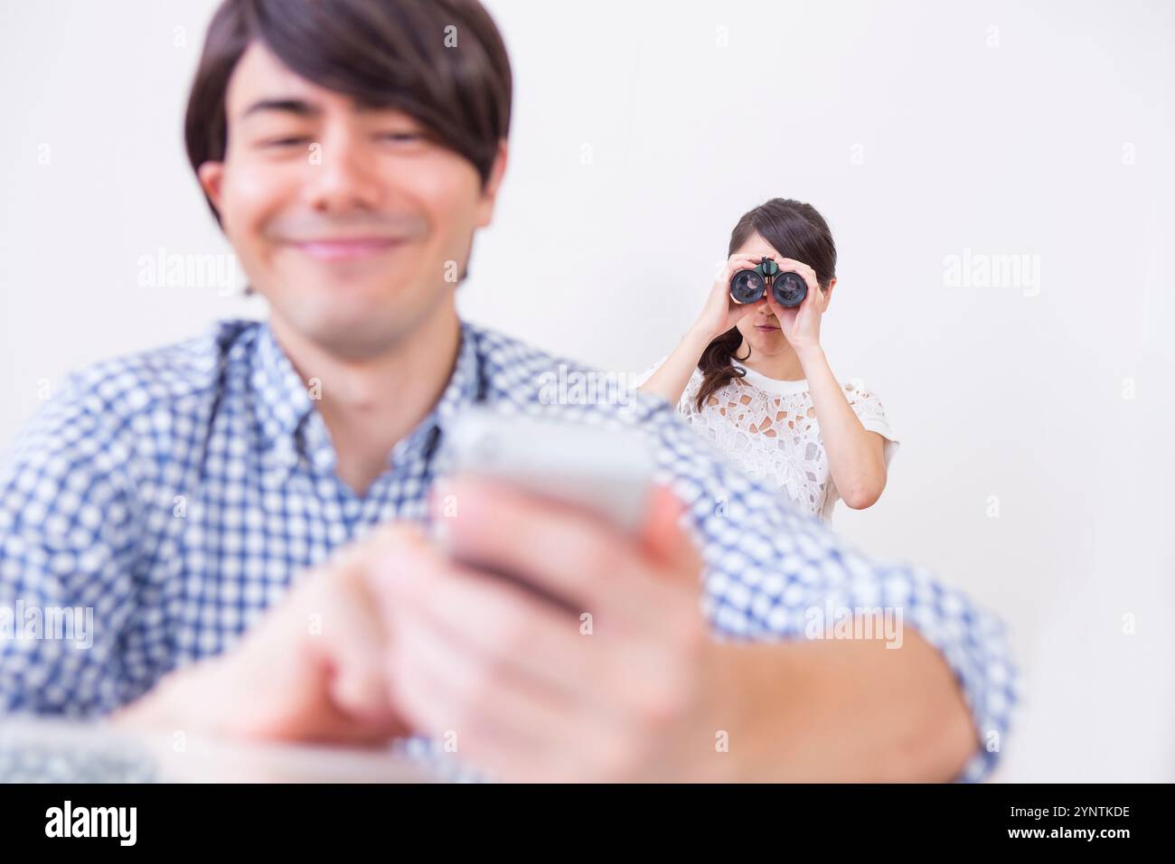Man fiddling with his phone and woman looking behind him Stock Photo ...