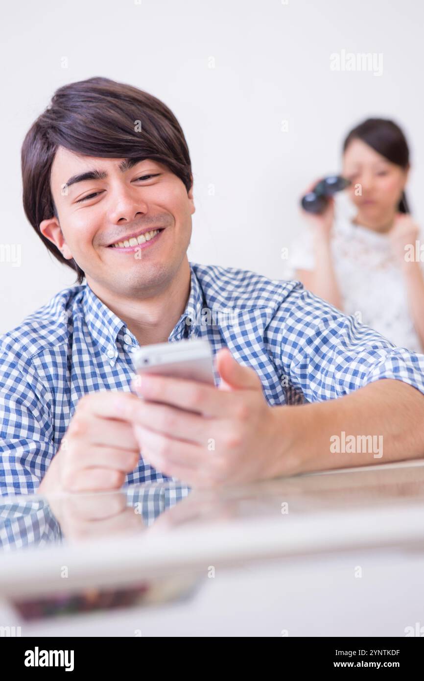 Man fiddling with his phone and woman looking behind him Stock Photo ...