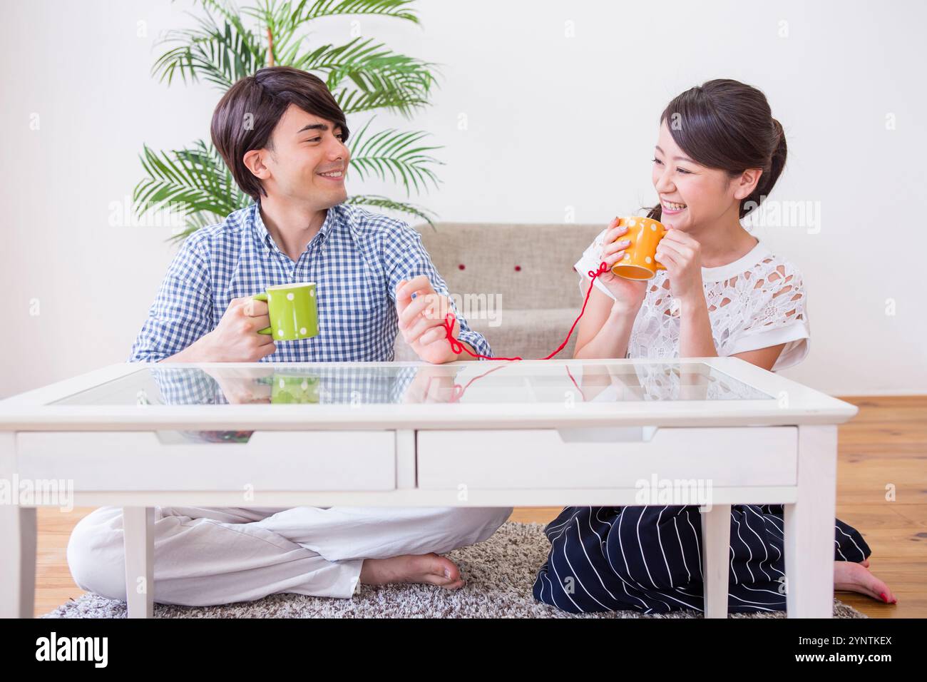 Man and woman connected by red thread Stock Photo - Alamy
