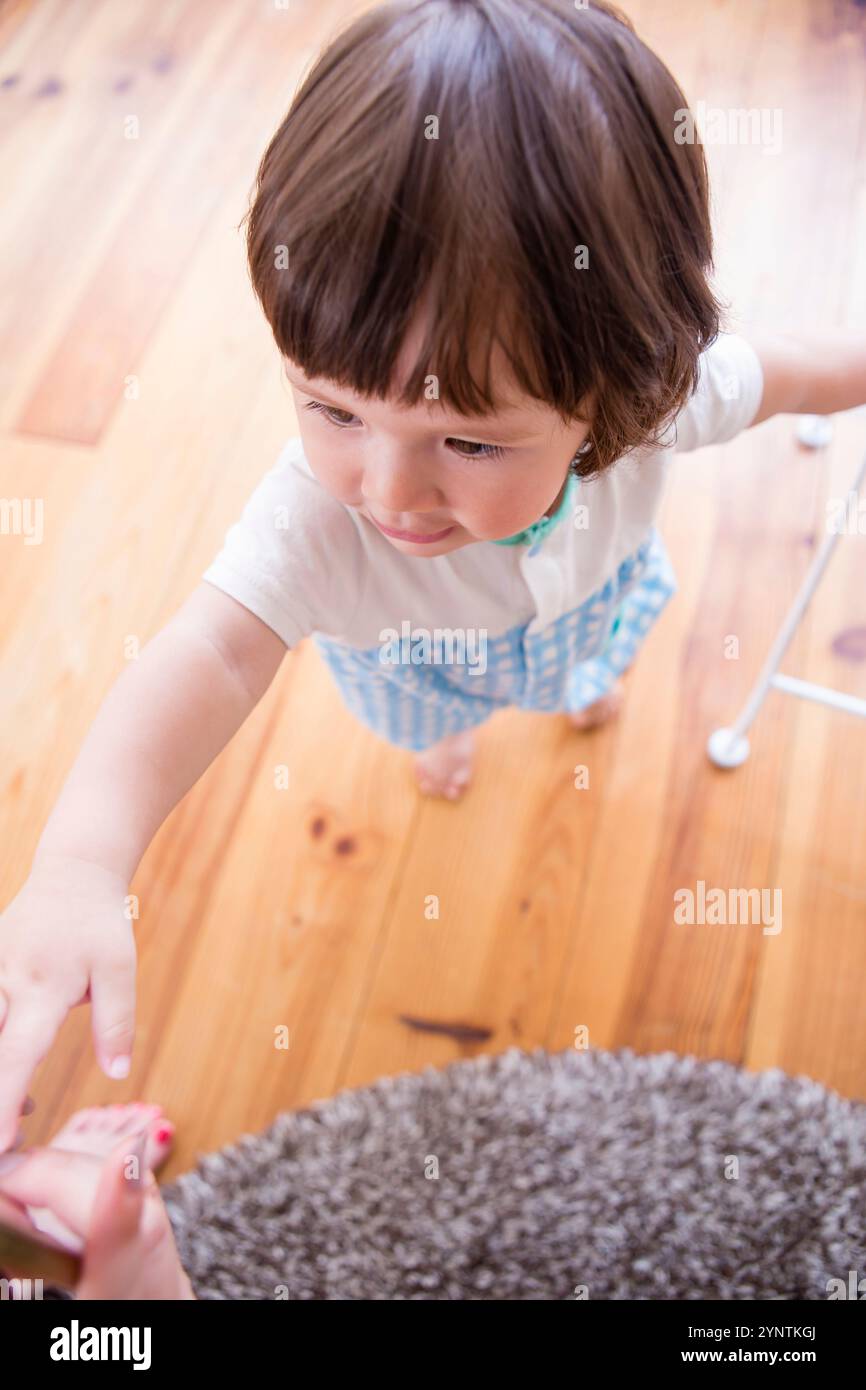 Child holding on to chair Stock Photo - Alamy