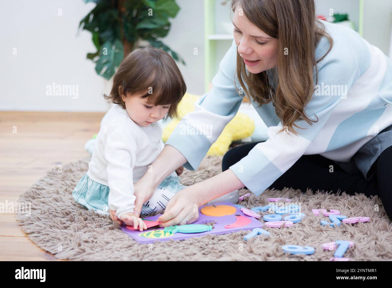 Parent and child playing in room Stock Photo - Alamy