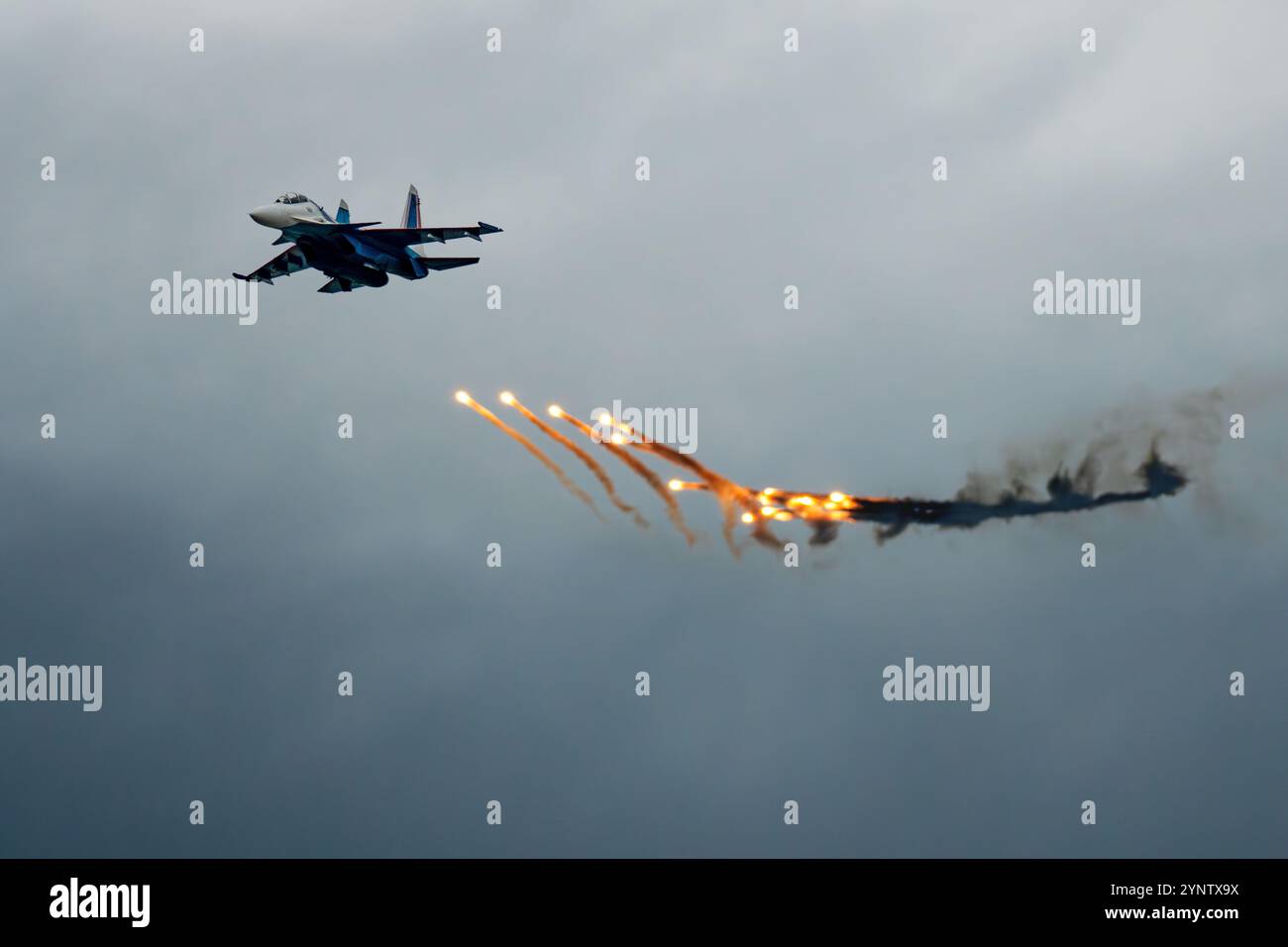 A military fighter plane flies in the sky and releases false thermal ...