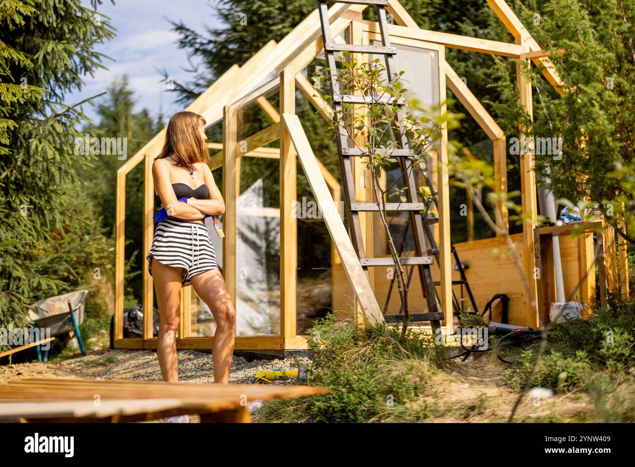Woman building wooden greenhouse at backyard Stock Photo - Alamy