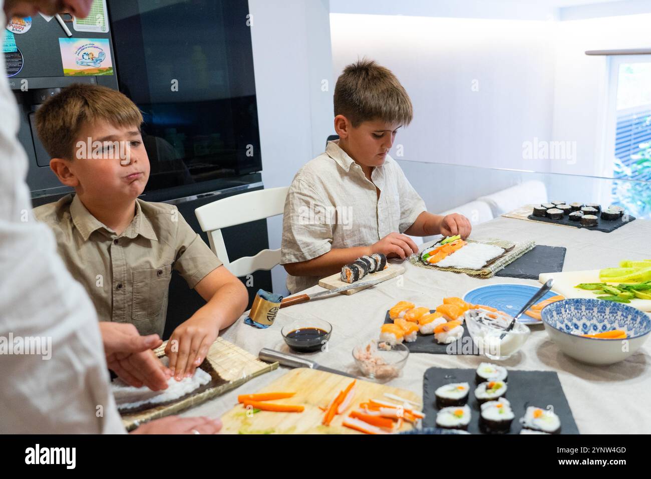 Two brother boys preparing sushi at home together Stock Photo - Alamy